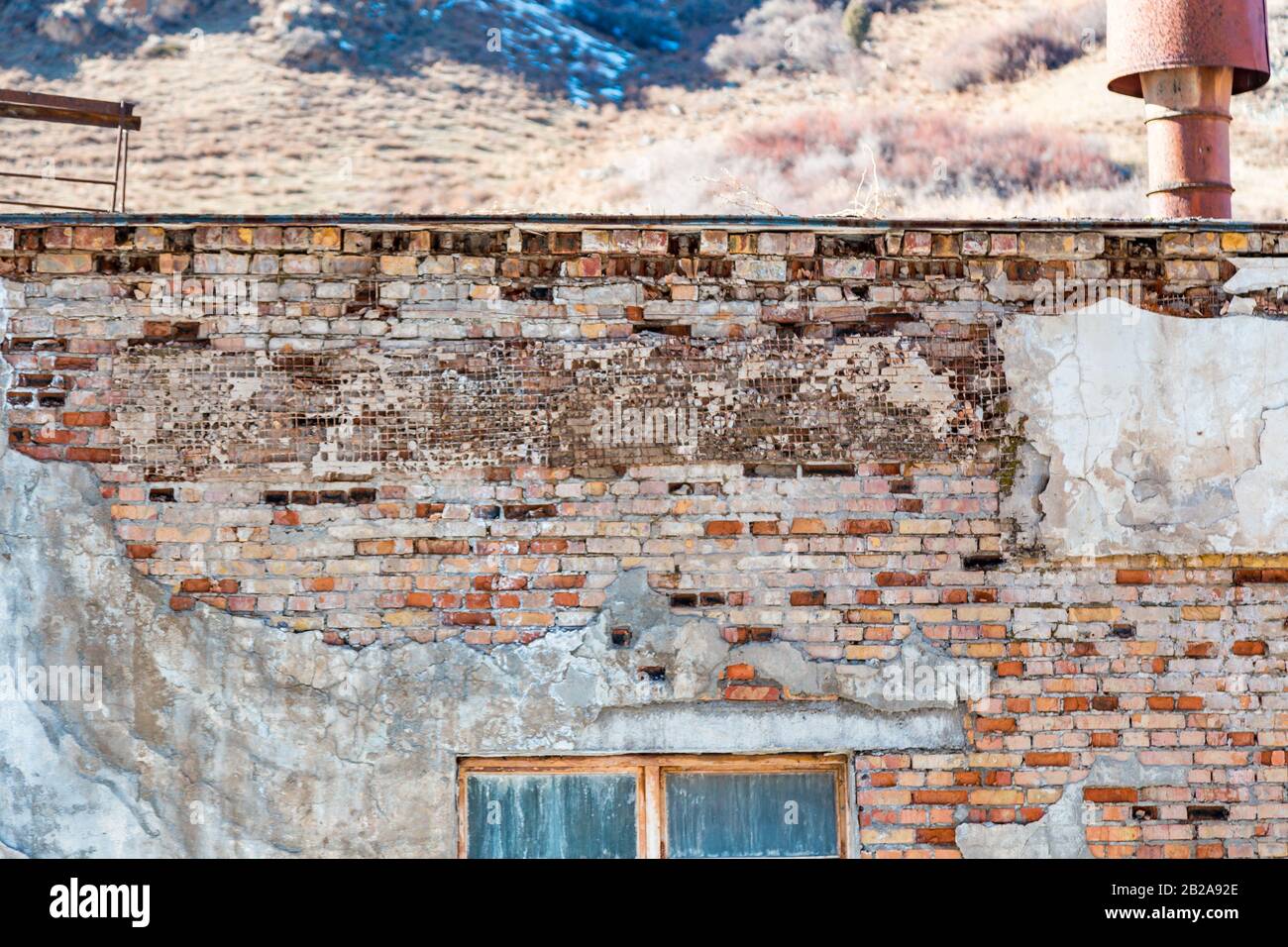 Texture of an old building with a window. Background ruined plaster ...