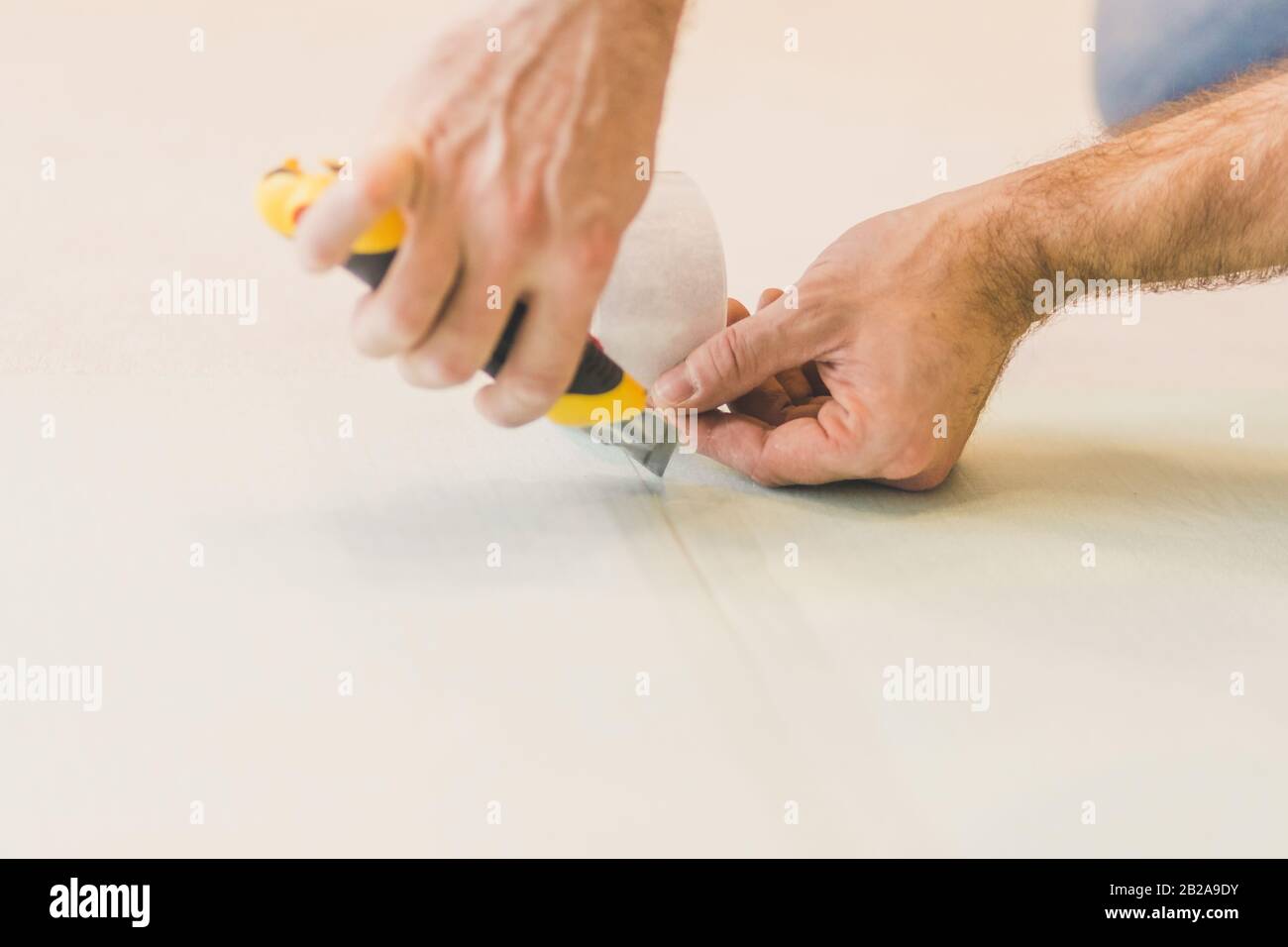 European man working at home - laying polystyrene substrate for laying ...