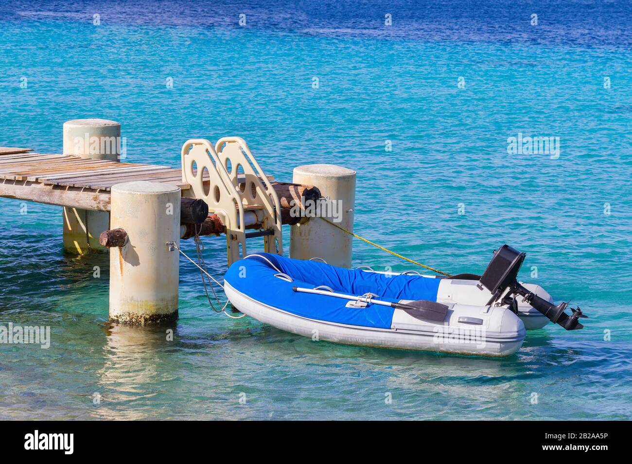 Fishing boat floating on sea near pier with stairs Stock Photo - Alamy