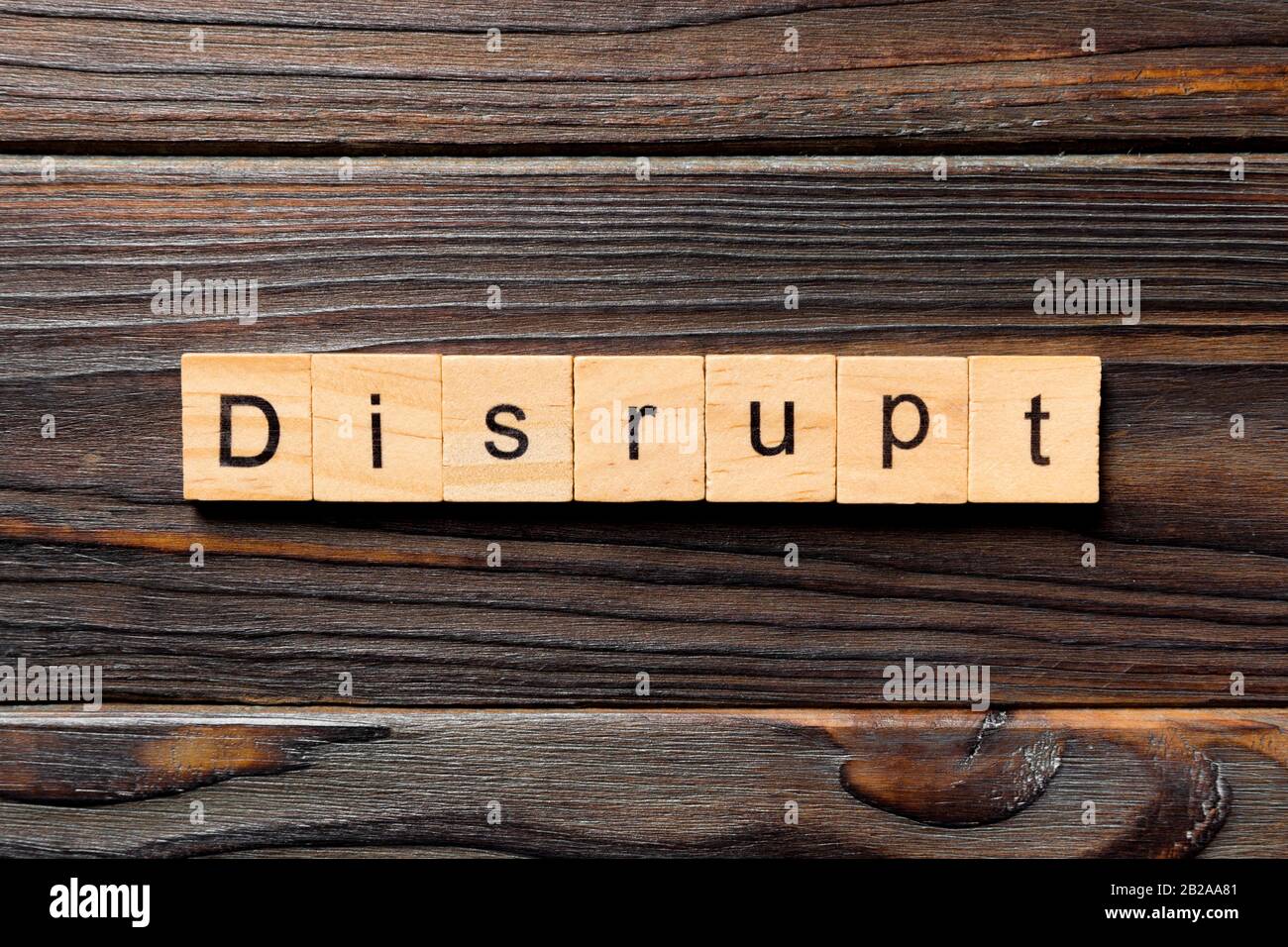 DISRUPT word written on wood block. DISRUPT text on wooden table for ...
