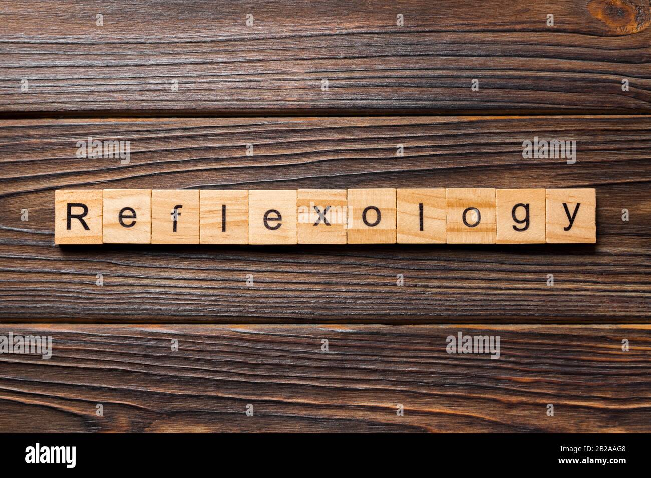 reflexology word written on wood block. reflexology text on wooden ...