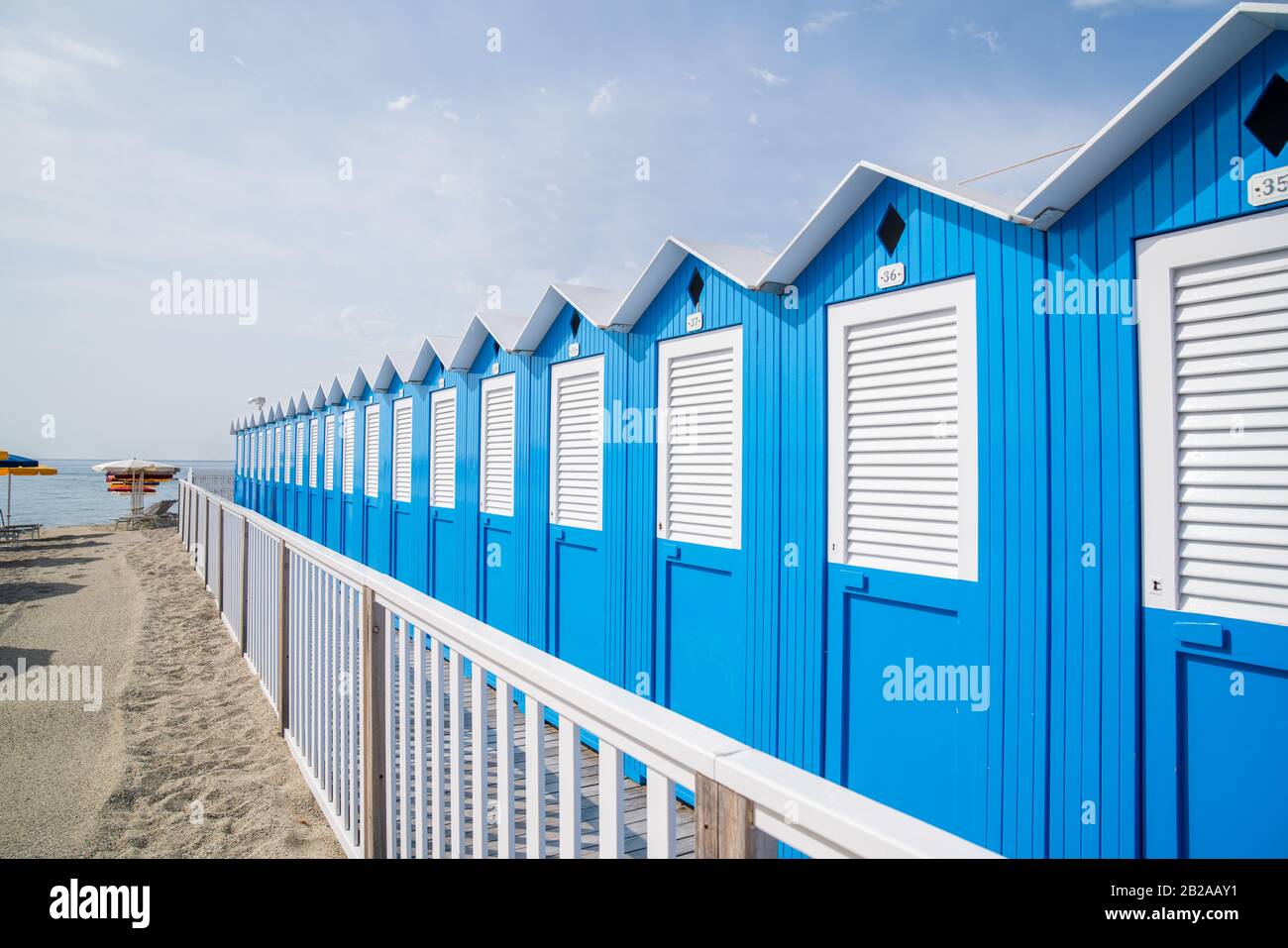 Traditional Italian beach huts on a bright sunny day,Blue beach cabins ...