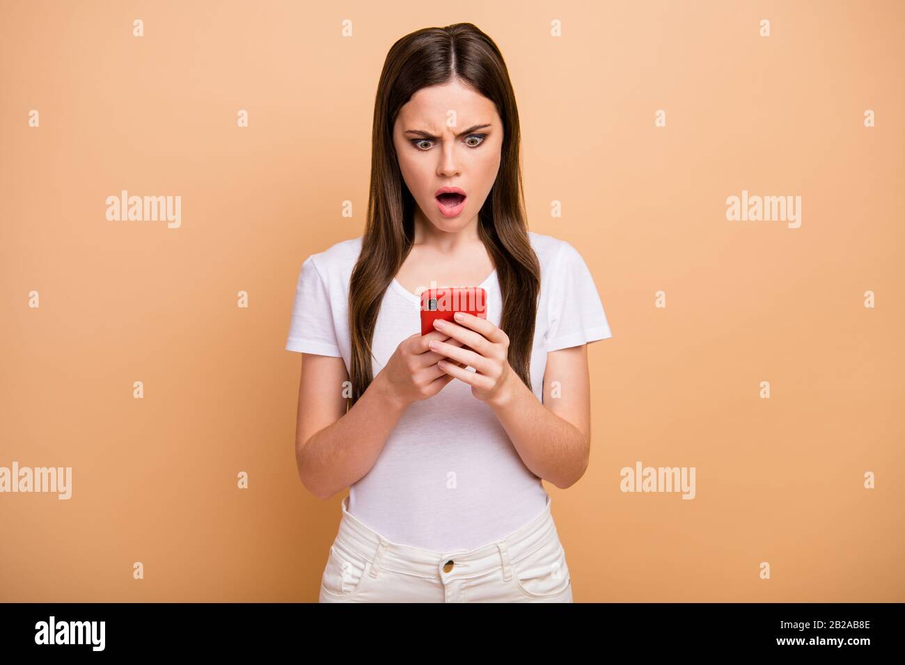 Portrait of astonished negative girl use mobile phone read social media ...