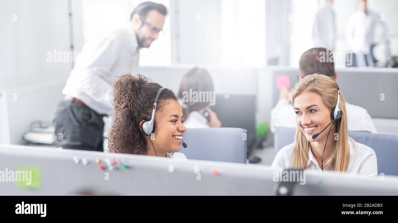 Call center worker accompanied by her team. Smiling customer support ...