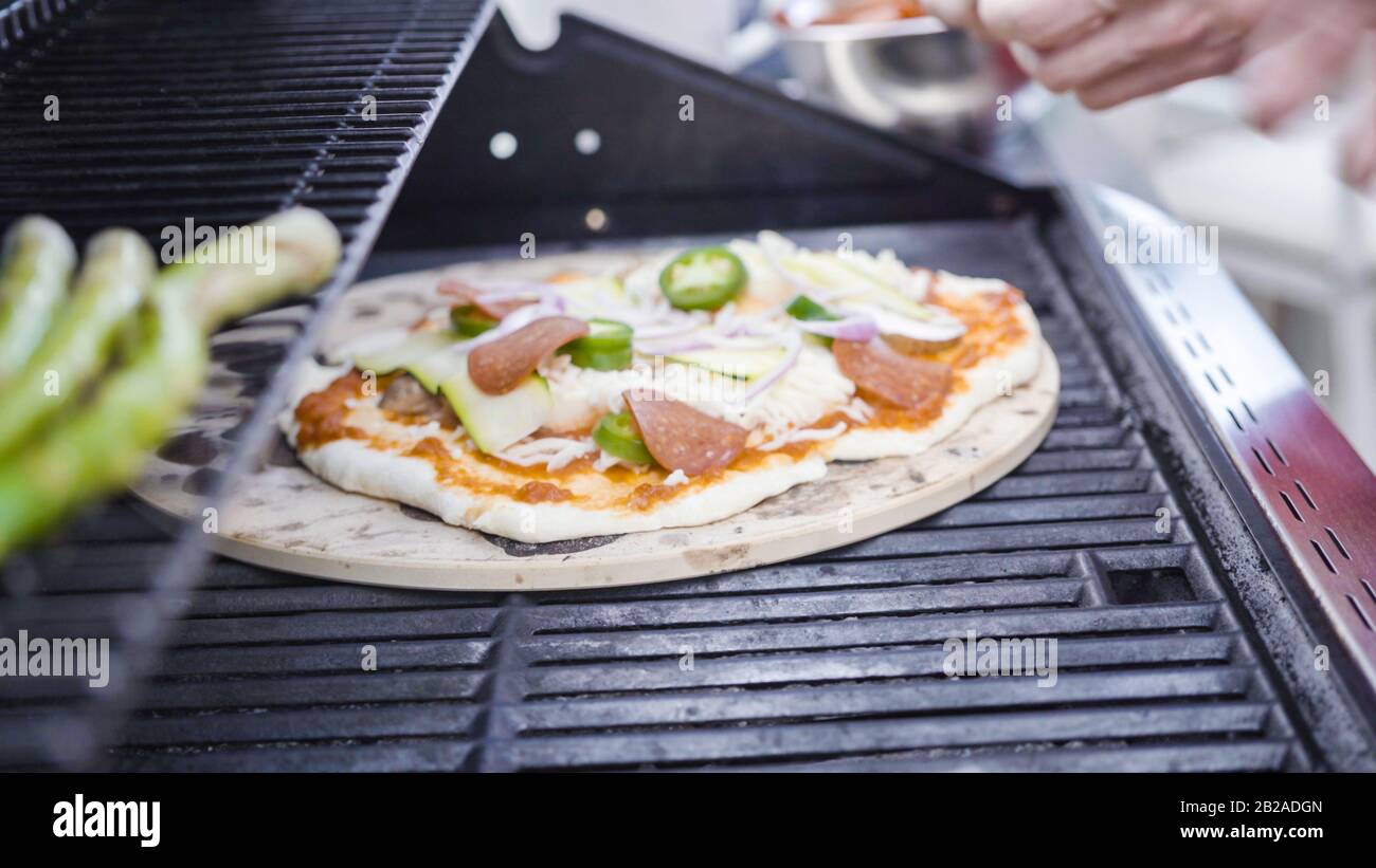 Cooking pizza on outdoor gas grill Stock Photo - Alamy