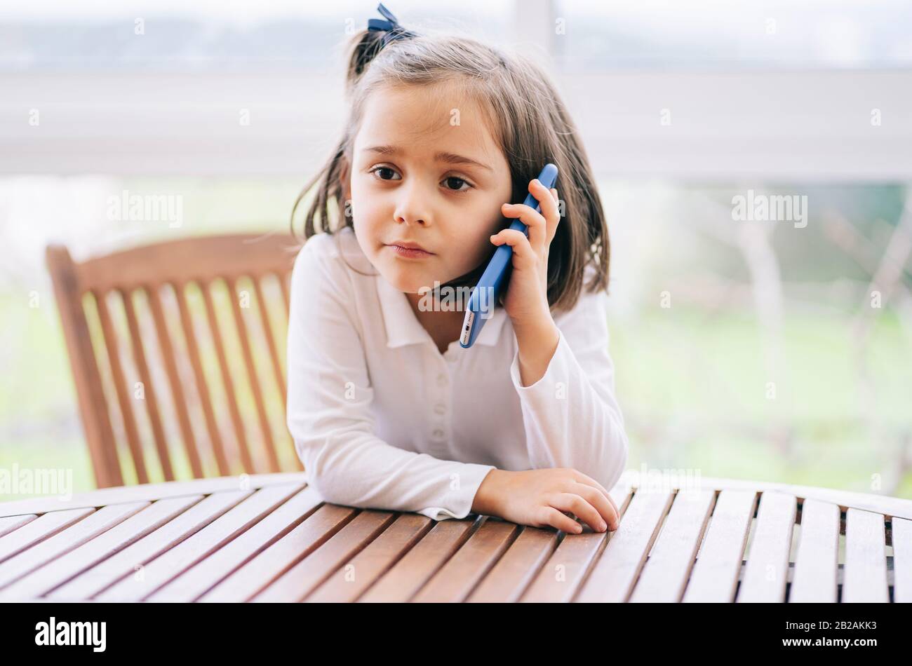 A little girl calls by mobile phone smartphone at home Stock Photo - Alamy