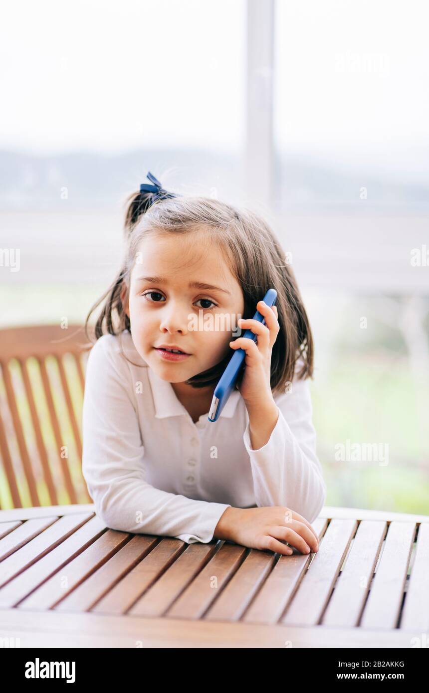 A little girl calls by mobile phone smartphone at home Stock Photo - Alamy