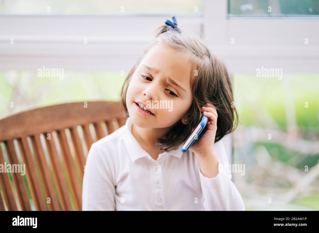 A little girl calls by mobile phone smartphone at home Stock Photo - Alamy
