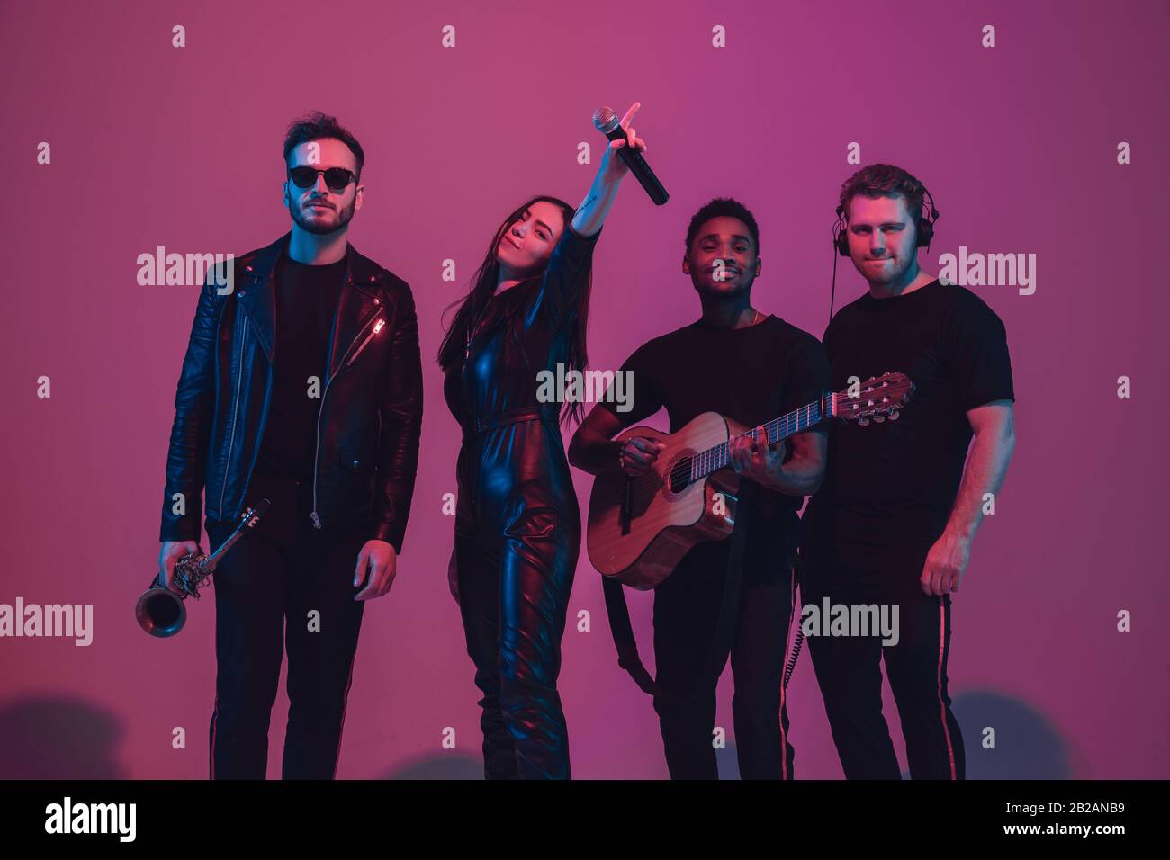 Group of young multiethnic musicians created band, dancing in neon ...