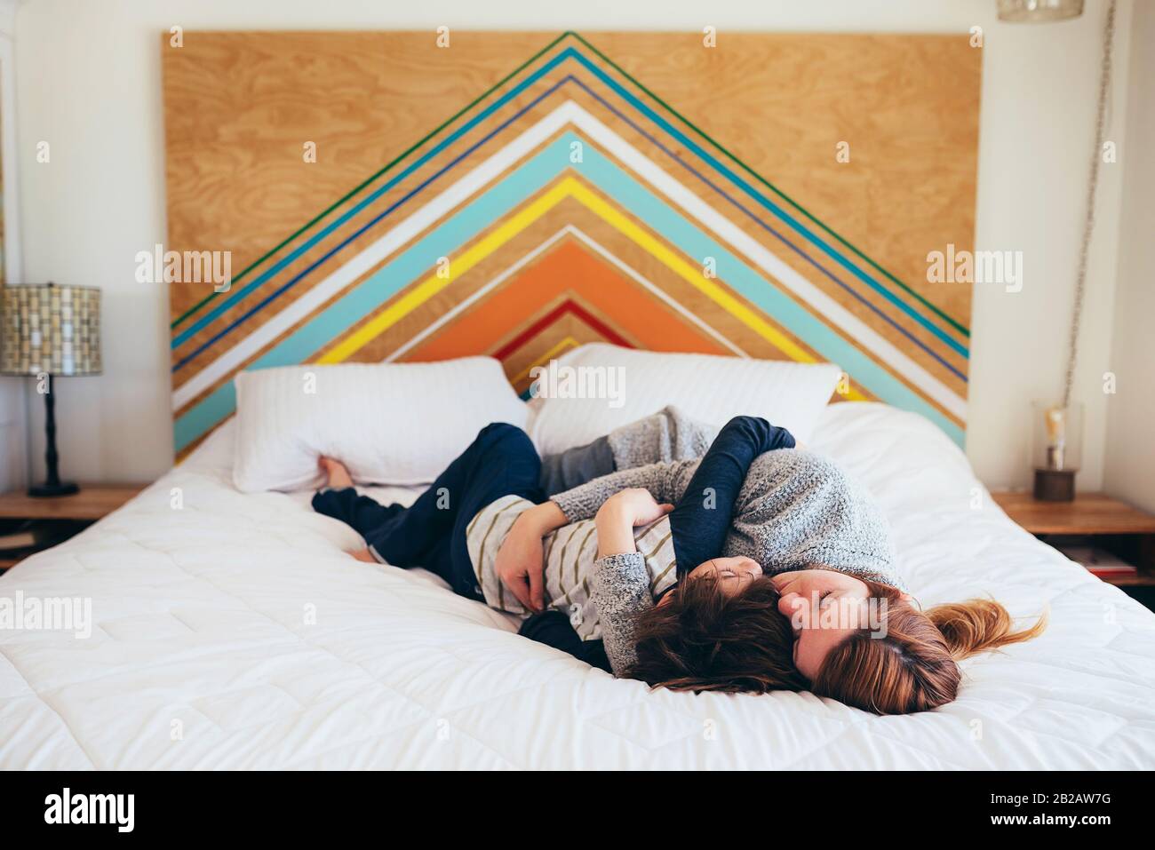 Mother and son lying on a bed cuddling Stock Photo - Alamy