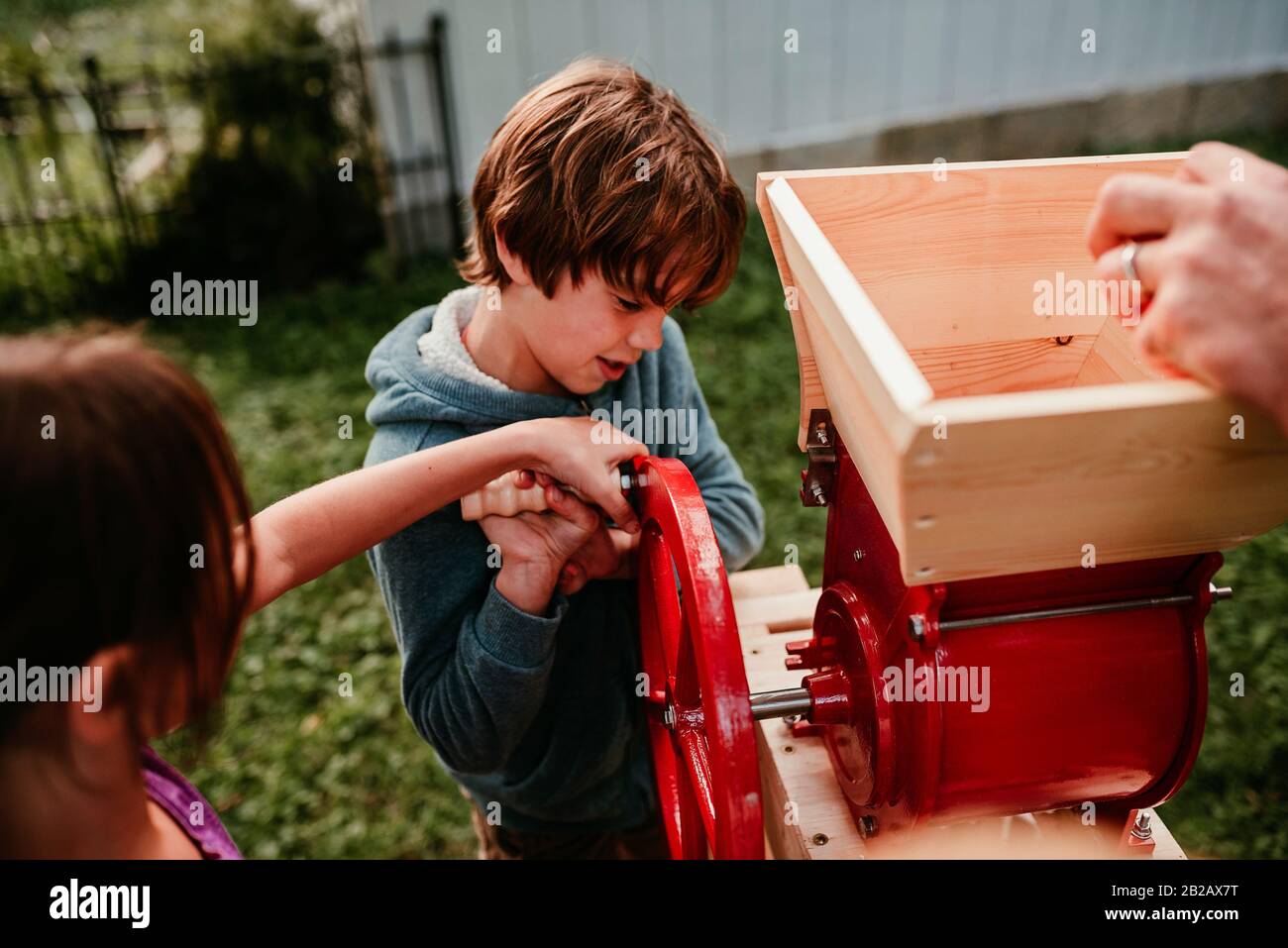 Two children helping their father press apples to make cider, USA Stock ...