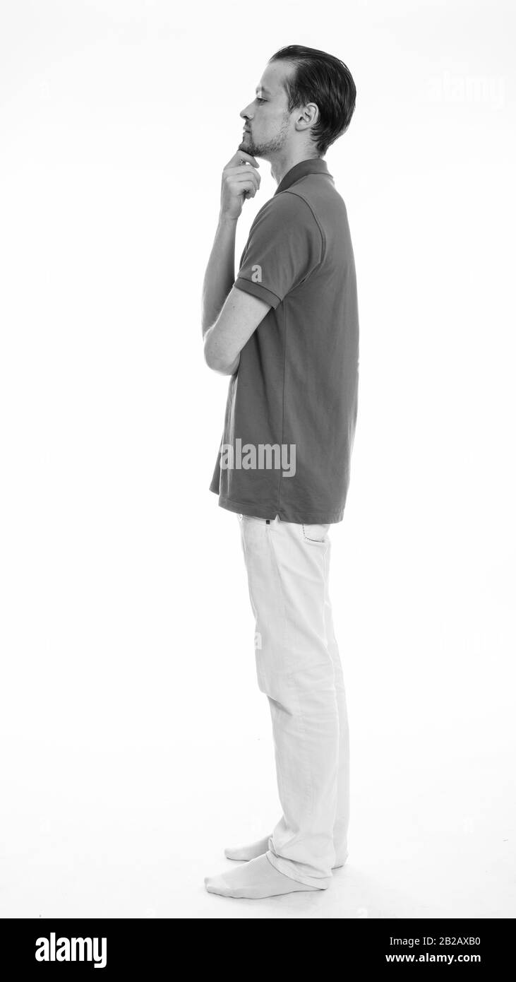 Full body shot profile view of young bearded man standing while ...