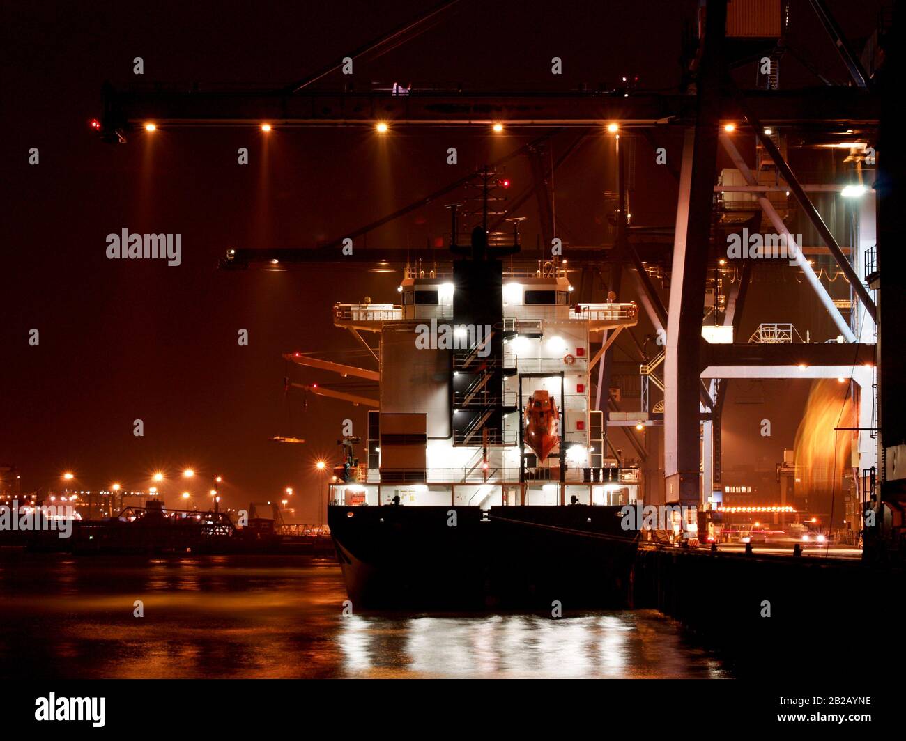 Containers Ships being loaded and unloaded at night under a big moon at ...
