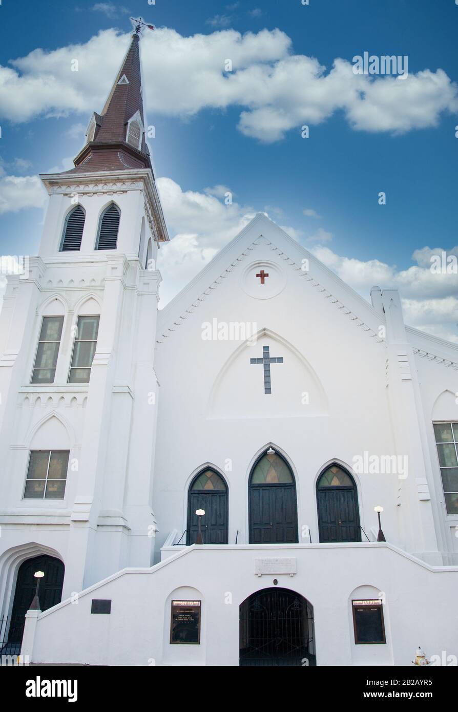 A classic old white plaster church with steeple and arched windows ...