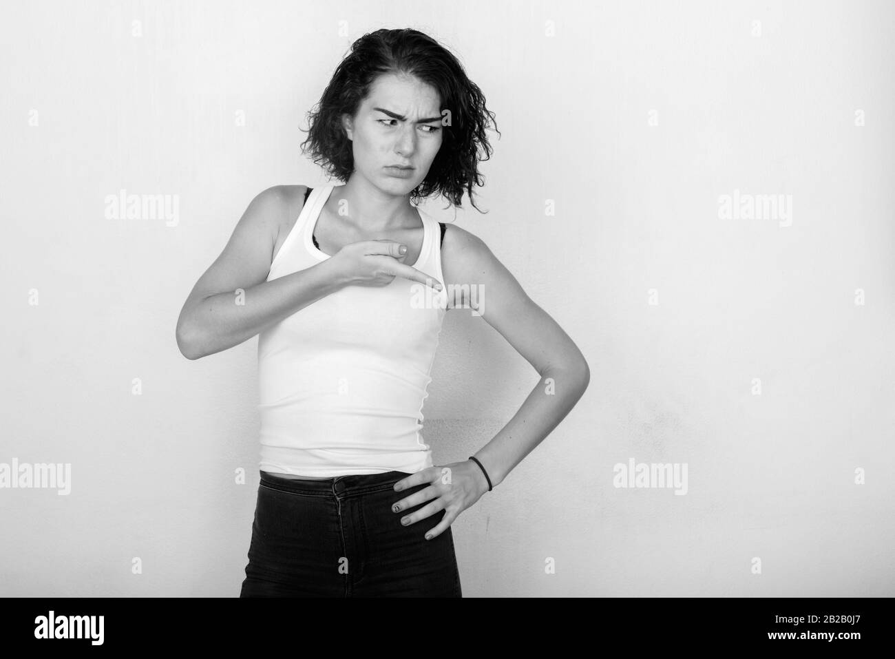 Studio shot of beautiful teenage girl looking disgusted while thinking ...
