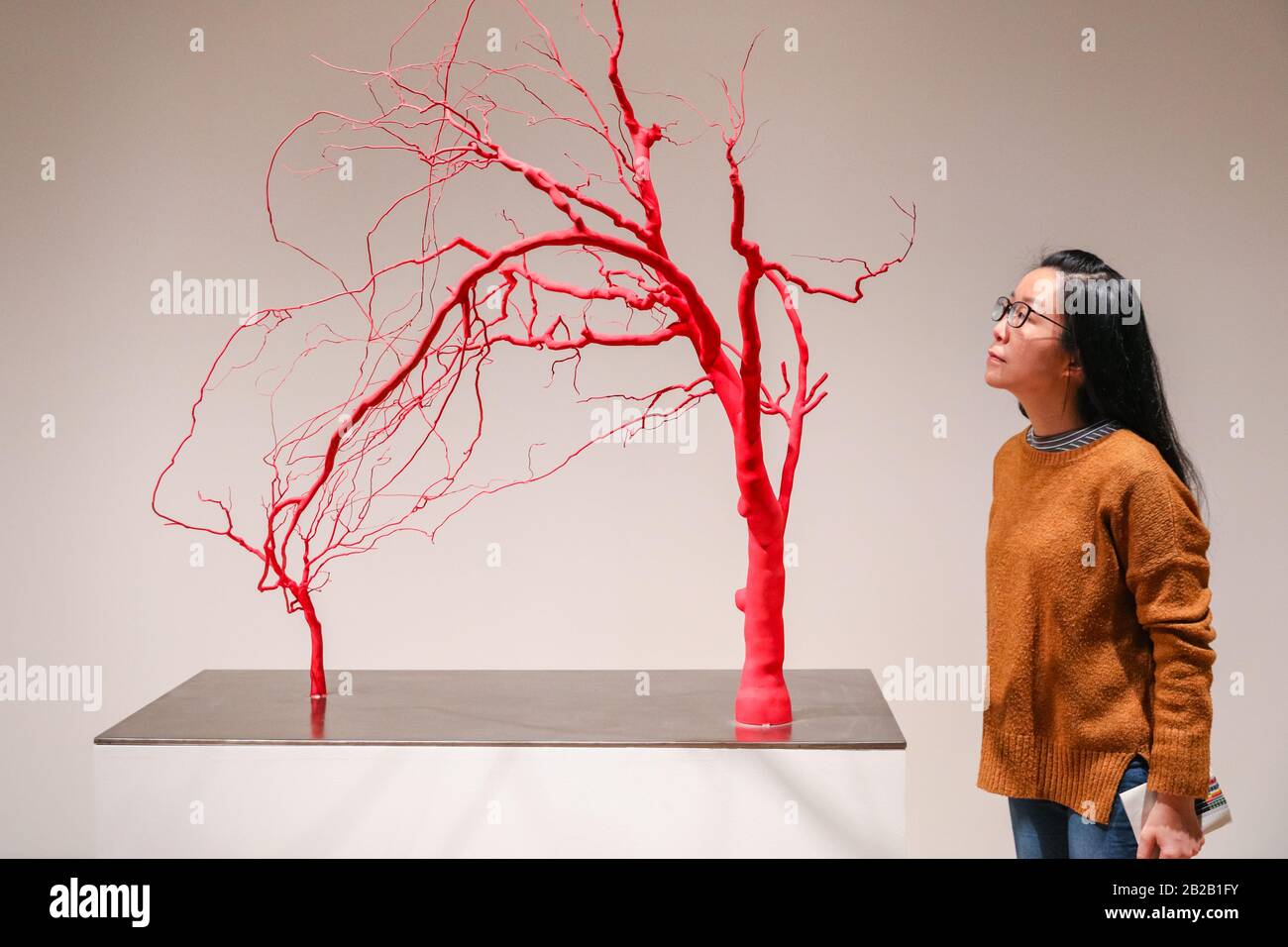 Hayward Gallery, London, UK. 2nd Mar, 2020. An assistant poses with 'Rotoplasm', a flame red ...
