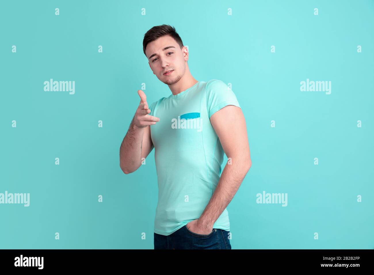 Pointing, choosing. Caucasian young man's portrait isolated on blue ...
