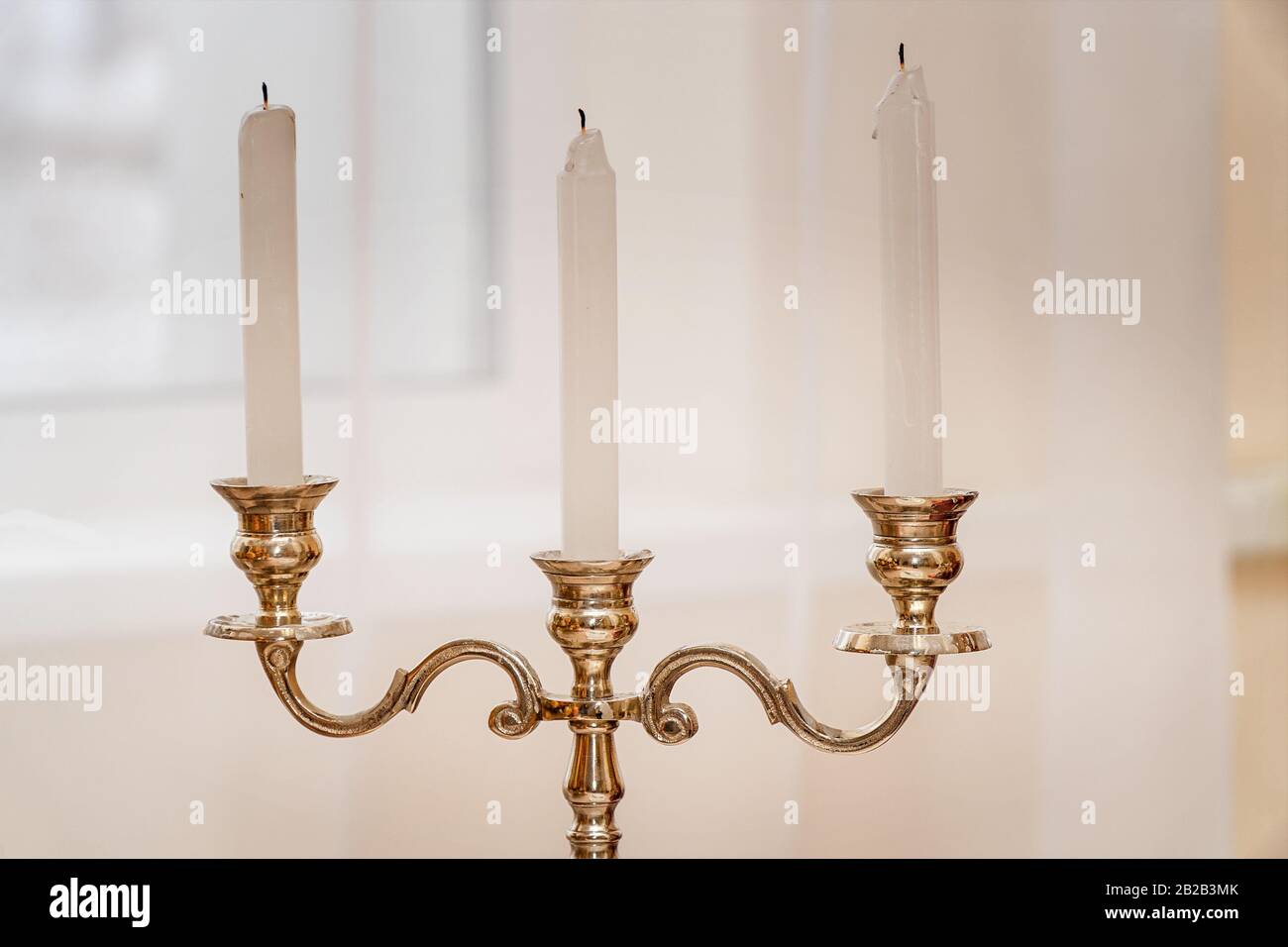 Antique gold candlestick with three candles on a light background Stock ...