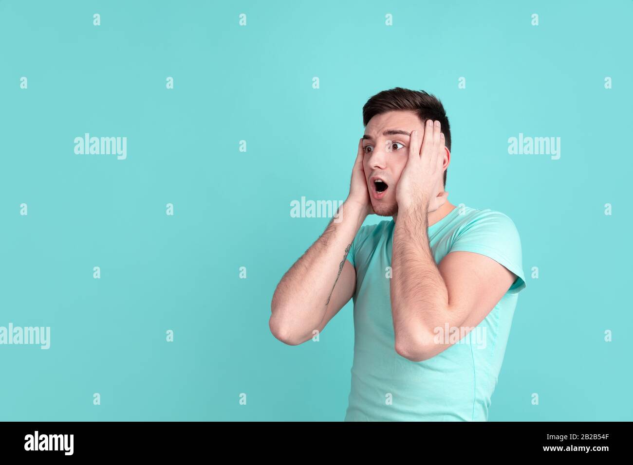 Shocked, astonished. Caucasian young man's portrait isolated on blue ...