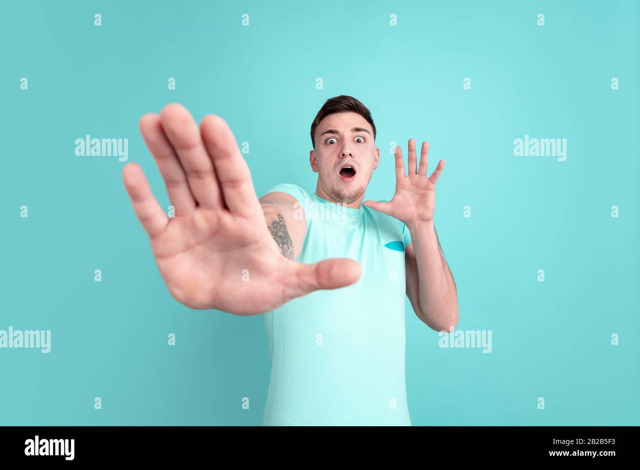 Rejecting, shocked. Caucasian young man's portrait isolated on blue ...