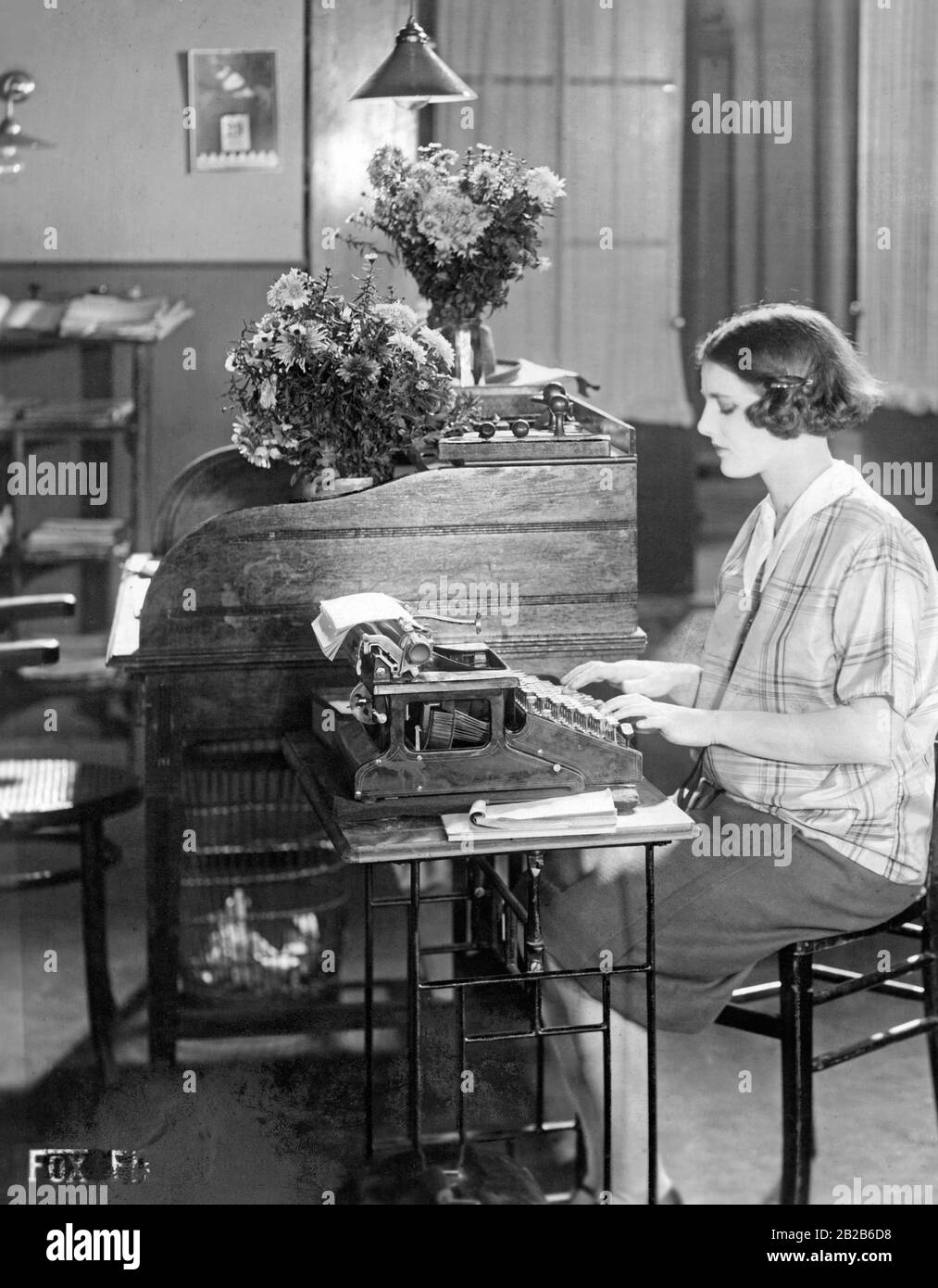 Office worker at the desk typing on a typewriter Stock Photo - Alamy