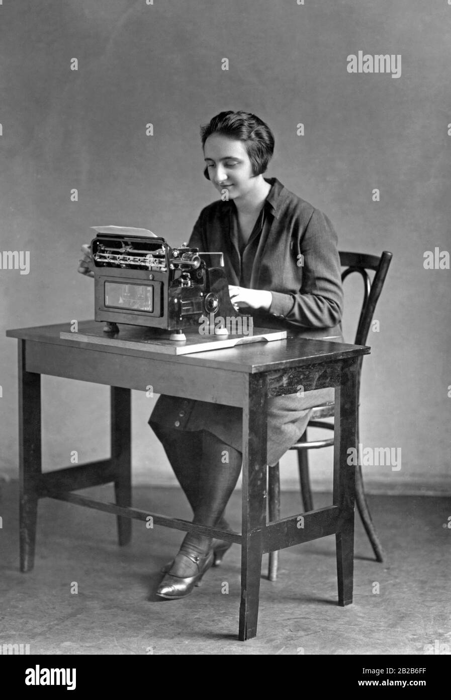 An office worker sits at a table and types on a typewriter Stock Photo ...