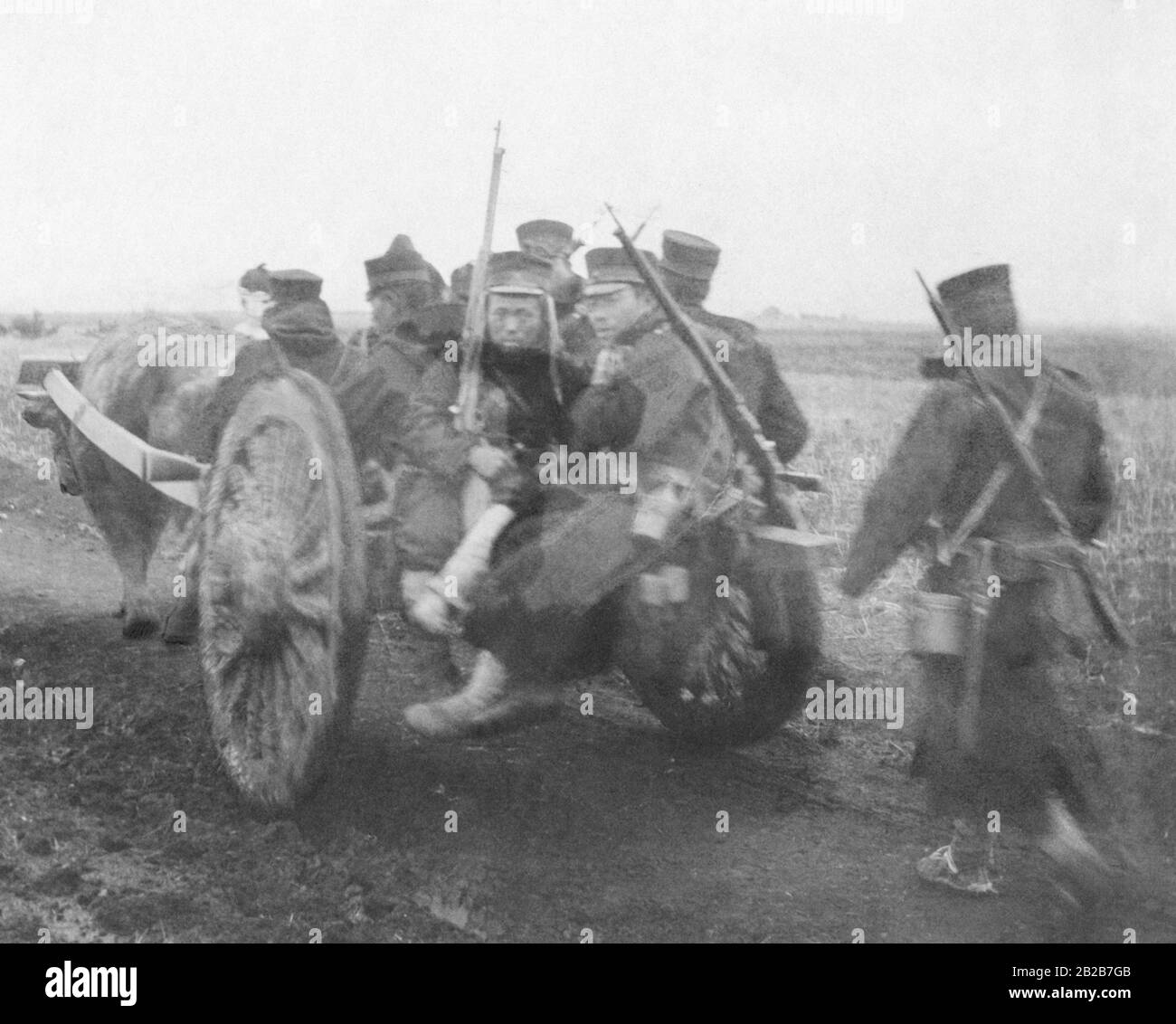 Japanese soldiers sitting on a cart pulled to the military hospital by ...