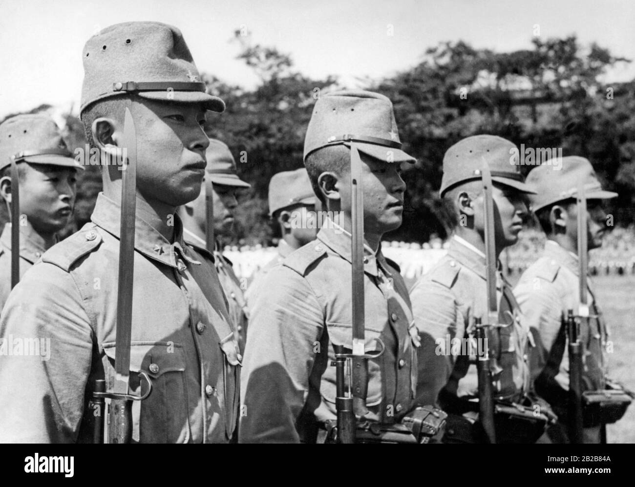 A group of Japanese soldiers is lined up on a military training area ...