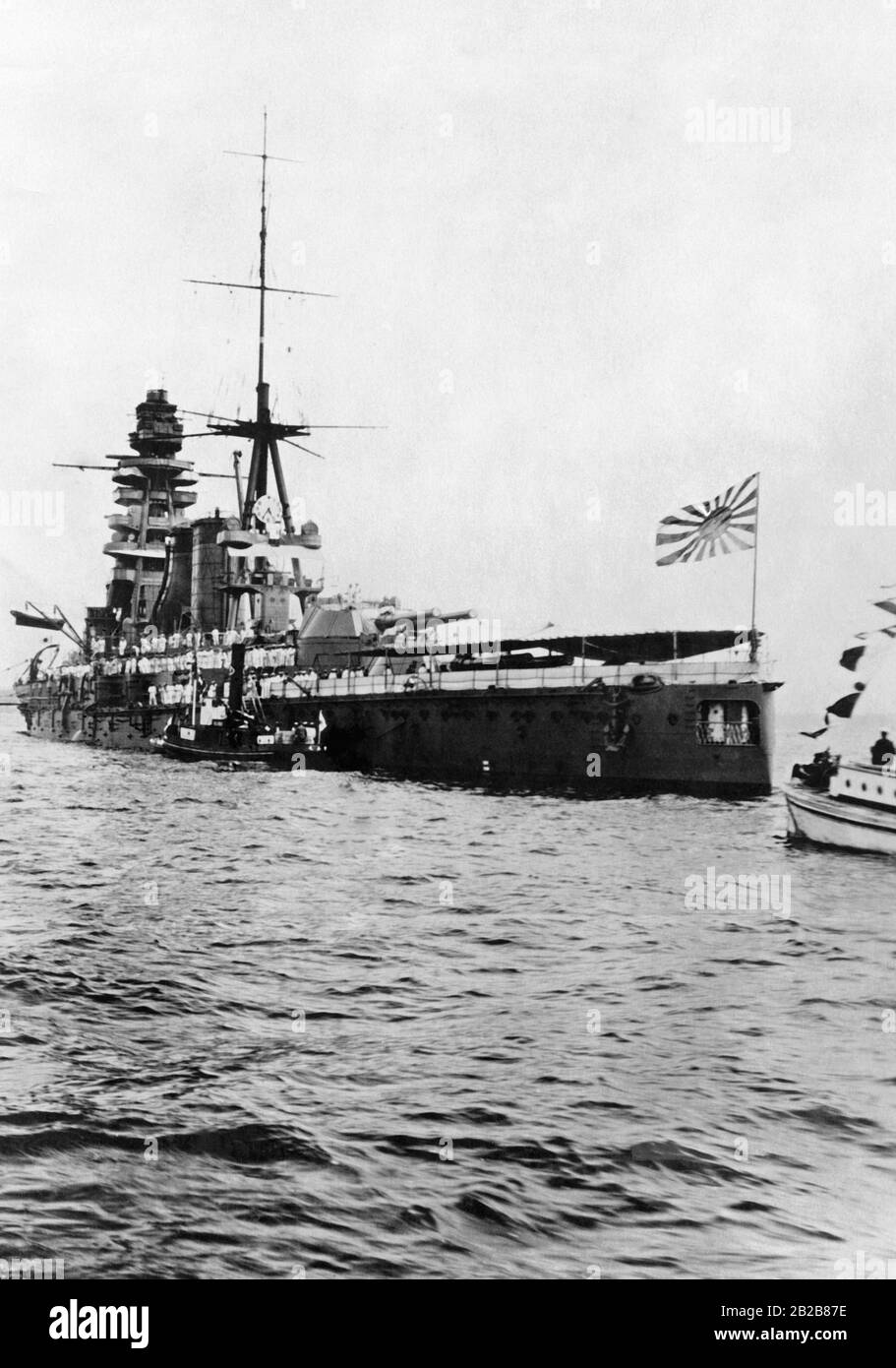 The Japanese warship Mutsu. The crew is on the deck. The flag of the ...