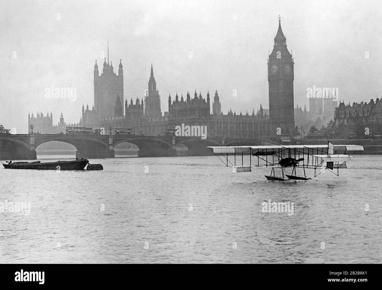 A seaplane on the Thames in front of the Parliament building in London ...