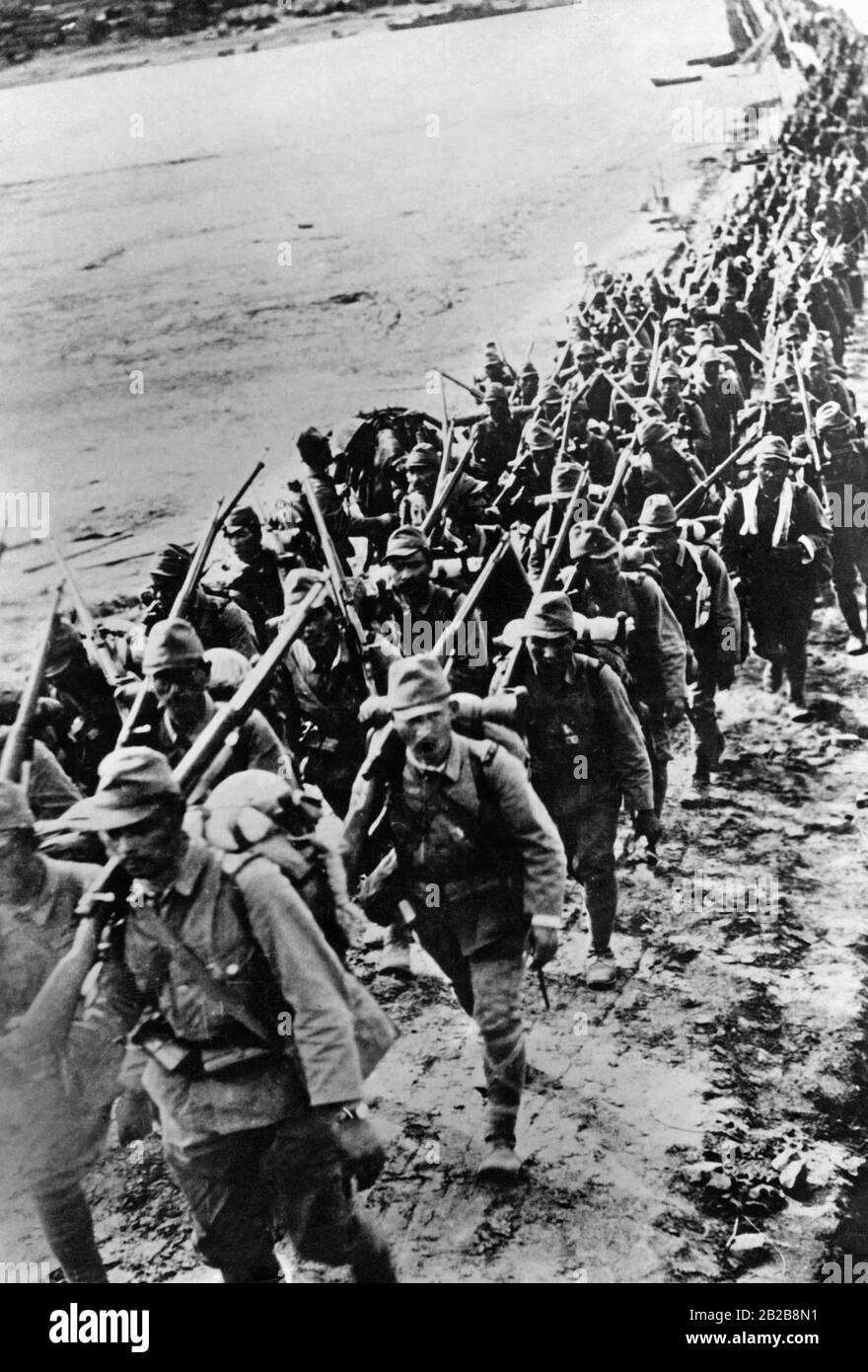 A troop of Japanese pioneers crosses a recently built temporary bridge ...