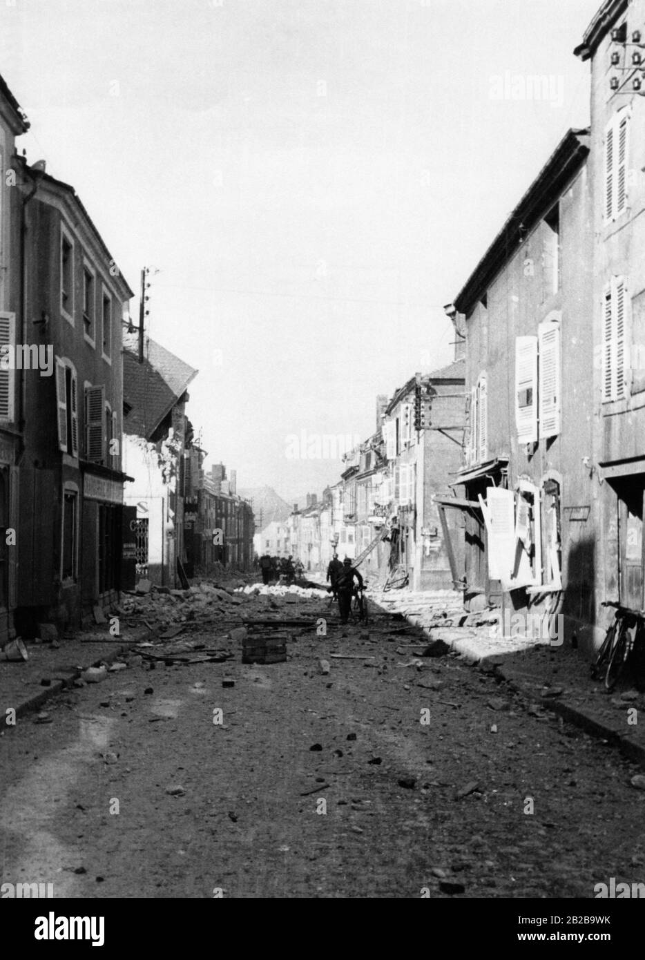 German soldiers advancing through a street destroyed during the ...