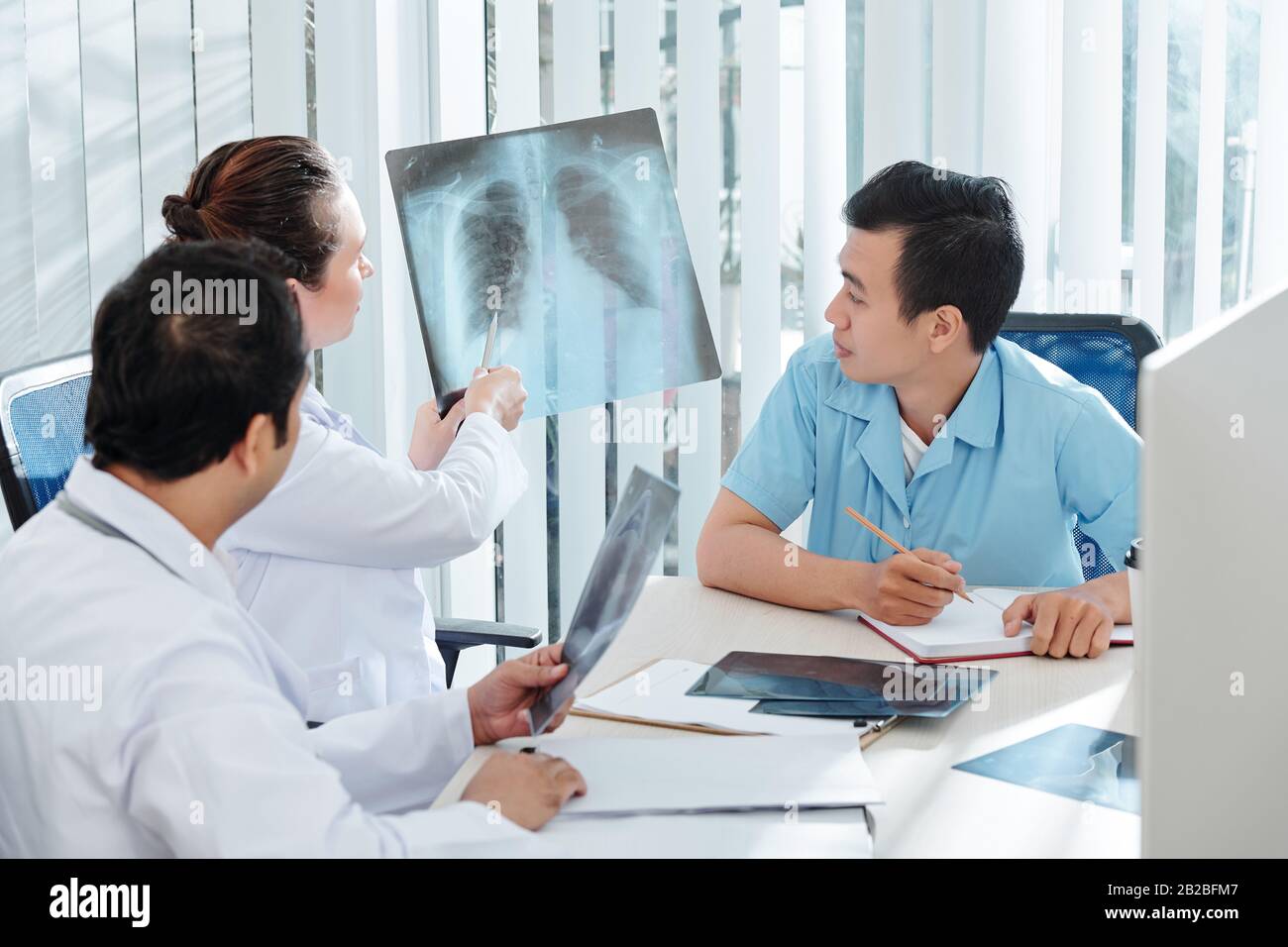Group of doctors discussing chest x-ray of patient with pneumonia and ...