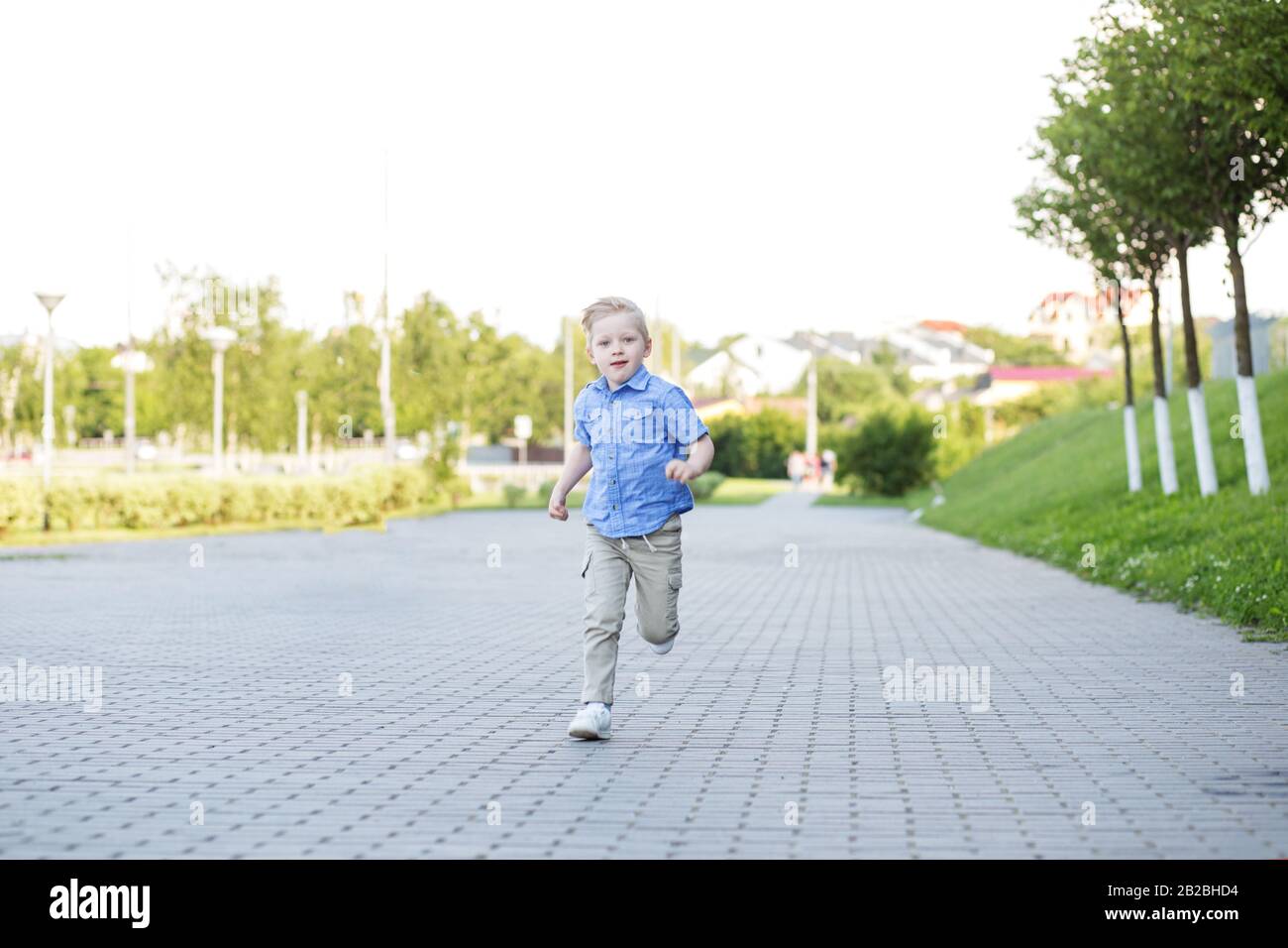 Child boy runs fast through the park. The concept is back to school ...