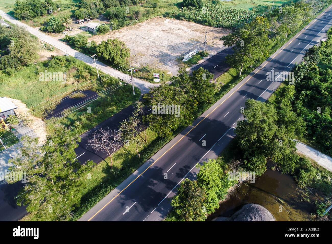 Aerial look down view of road path through the tree with car movement ...