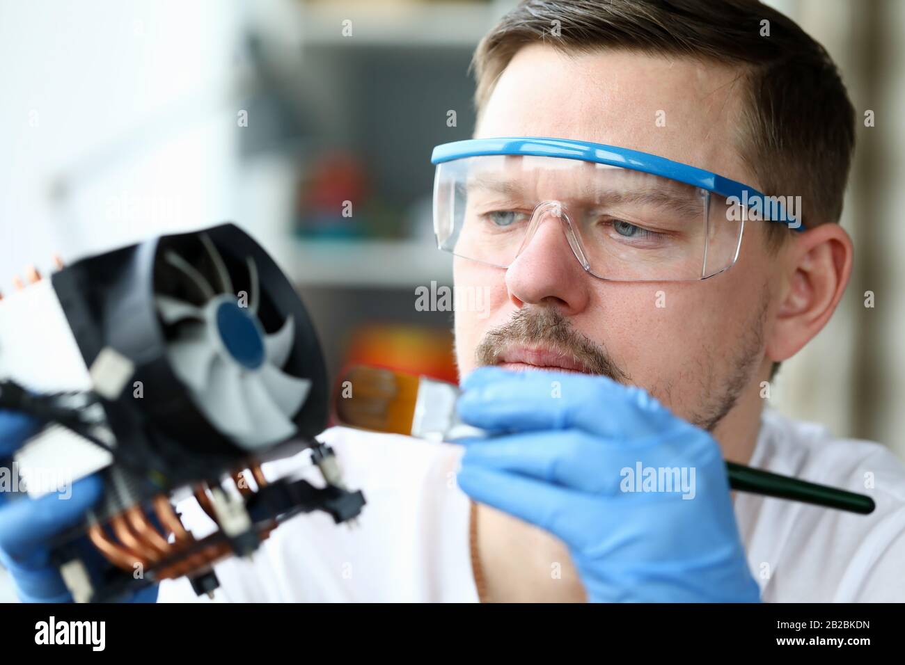 Masked man repairs and dusts a computer part Stock Photo - Alamy