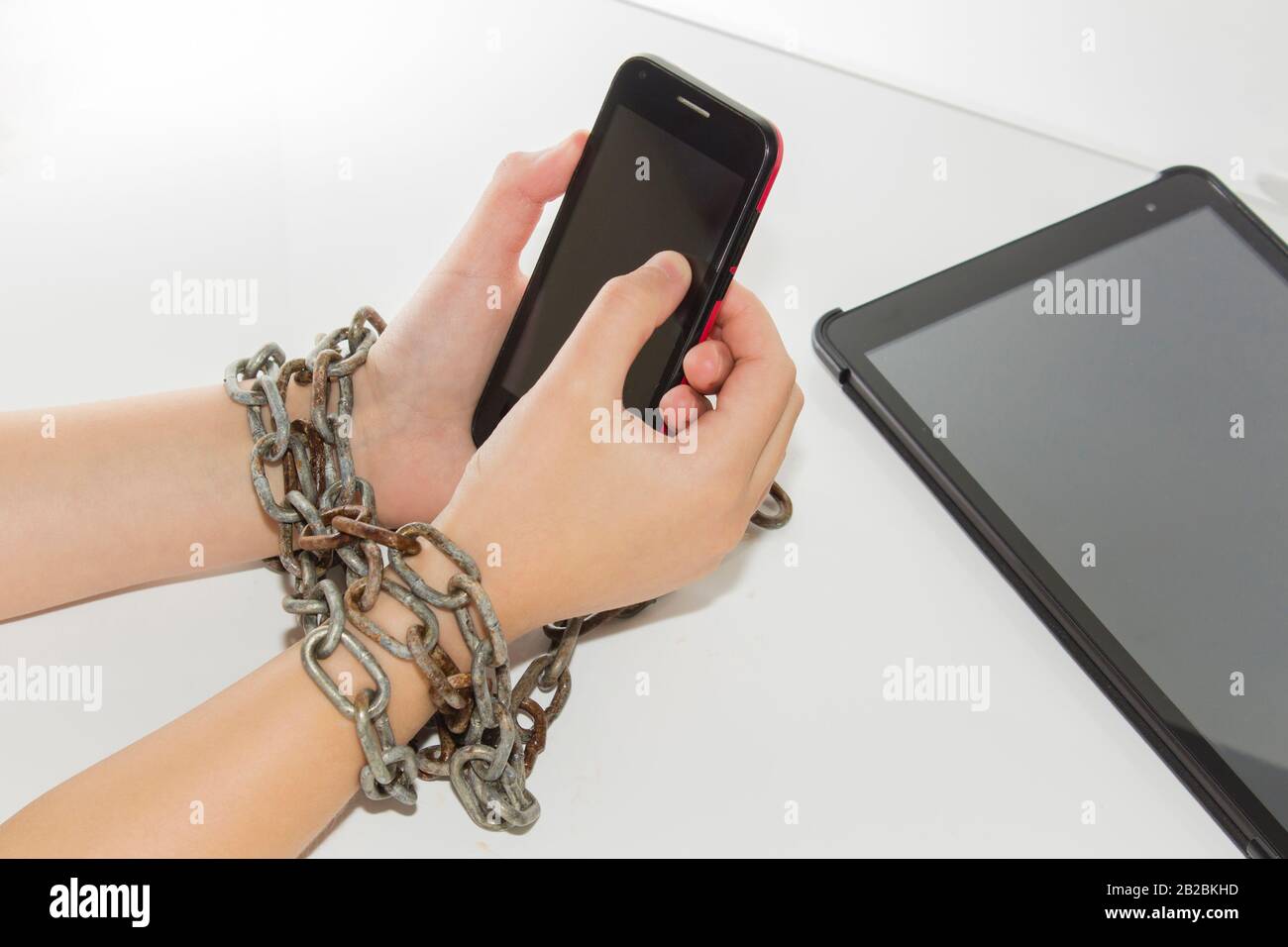 Iron chain ties together hands and smartphone - mobile phone addiction ...