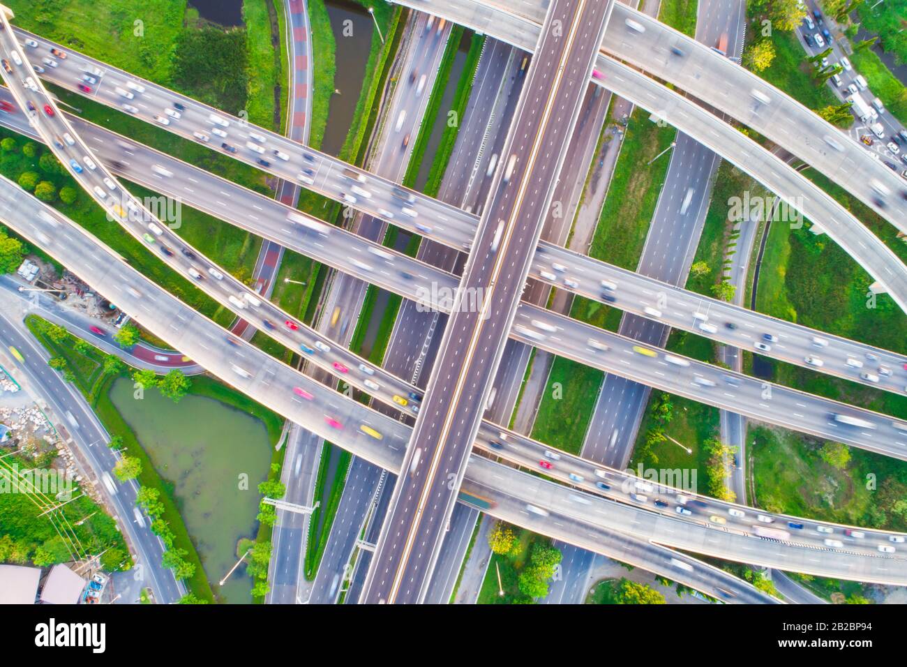 Aerial view car movement on traffic junction road with green tree park ...