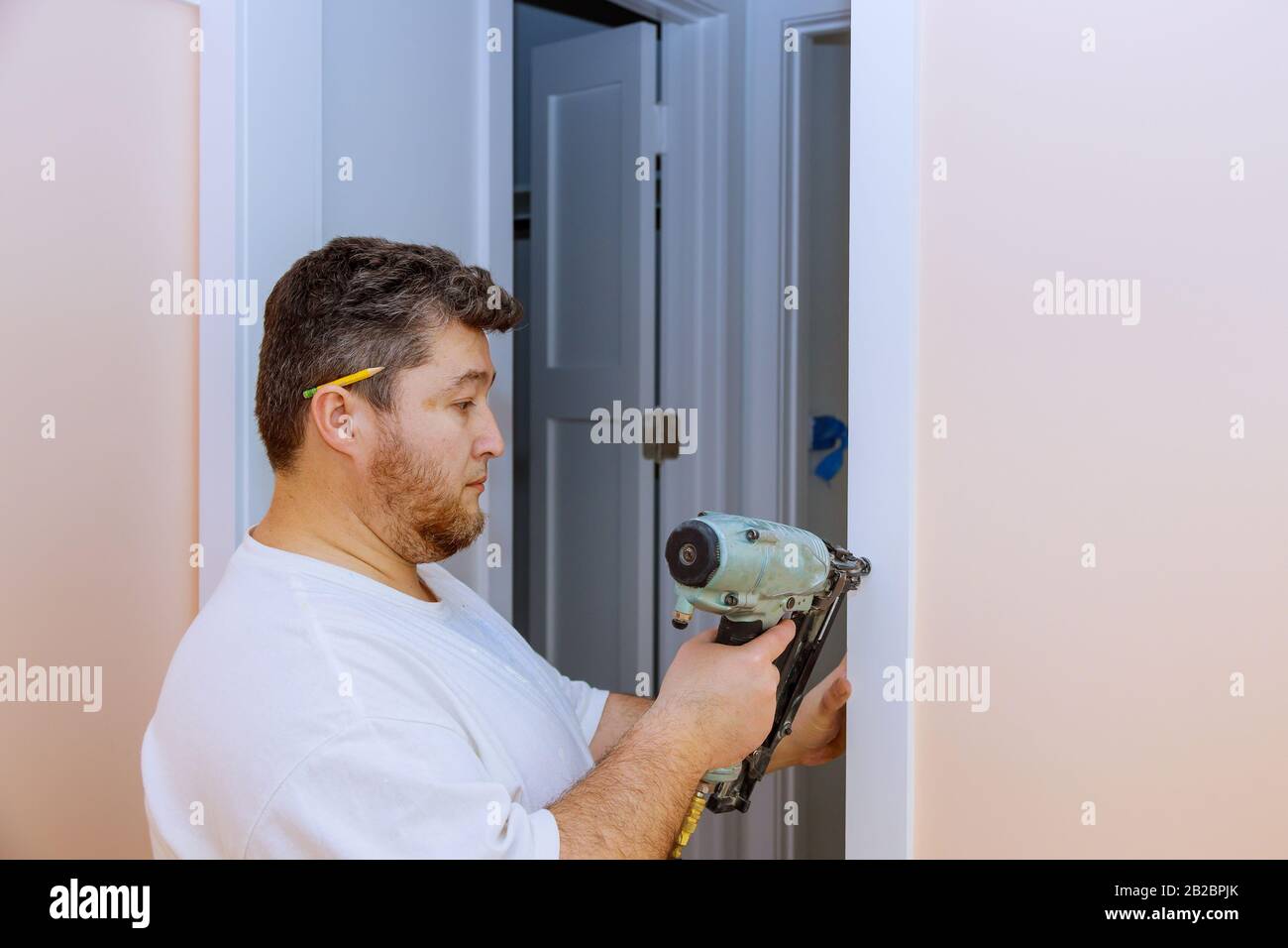 Construction handyman is working on renovation of apartment using air ...