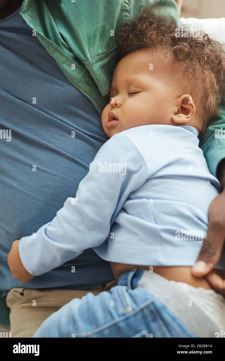 Above view at cute mixed-race baby sleeping in fathers arms Stock Photo ...