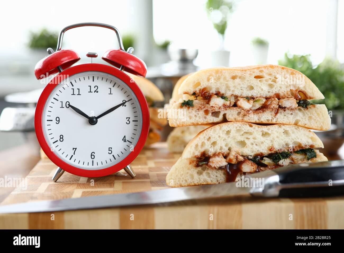 Red alarm clock with sandwich stands on wooden table background Stock ...
