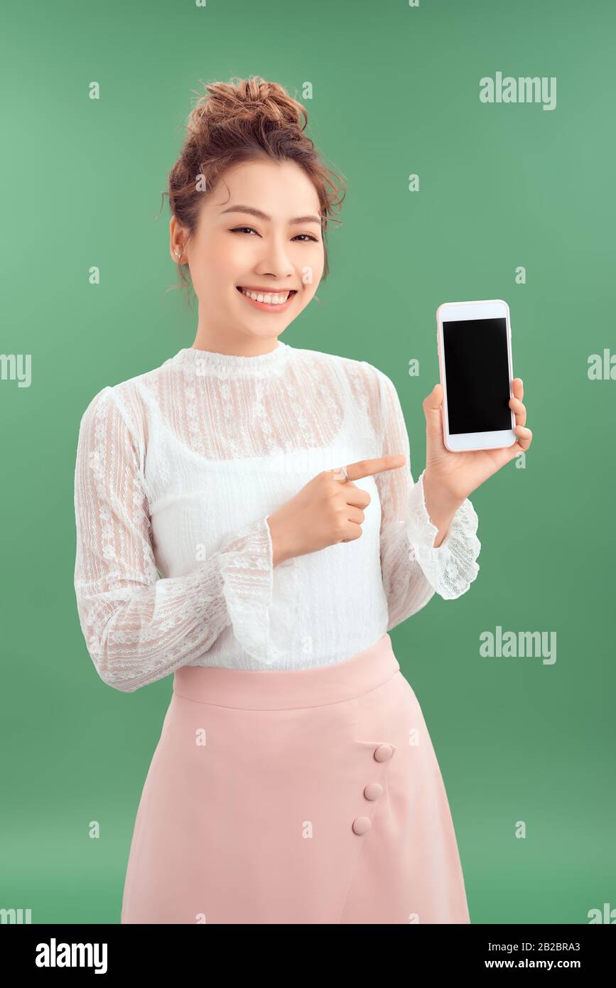 Surprised happy Asian woman showing blank smartphone screen and ...