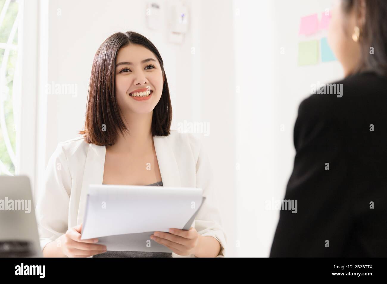 A young attractive asian woman is interviewing for a job. Her ...