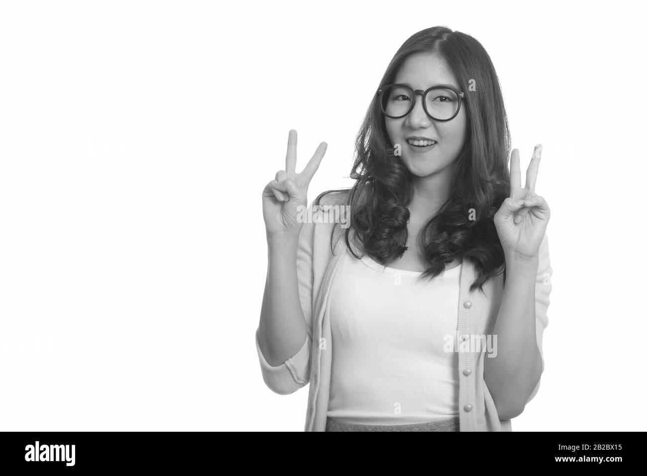 Young happy Asian woman giving peace sign Stock Photo - Alamy
