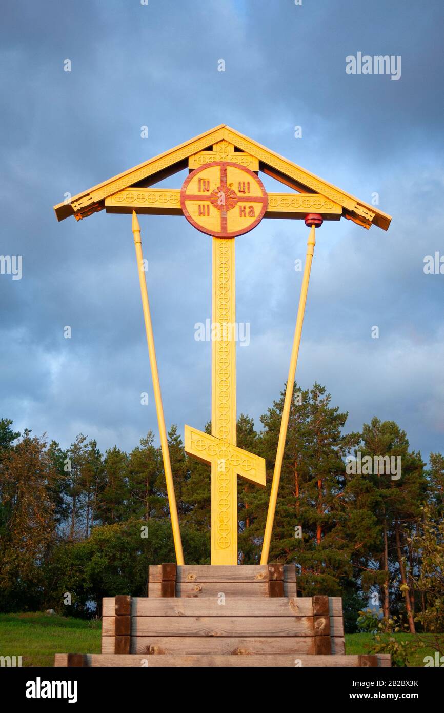 Wooden yellow christian orthodox cross near trees. Religious symbol ...