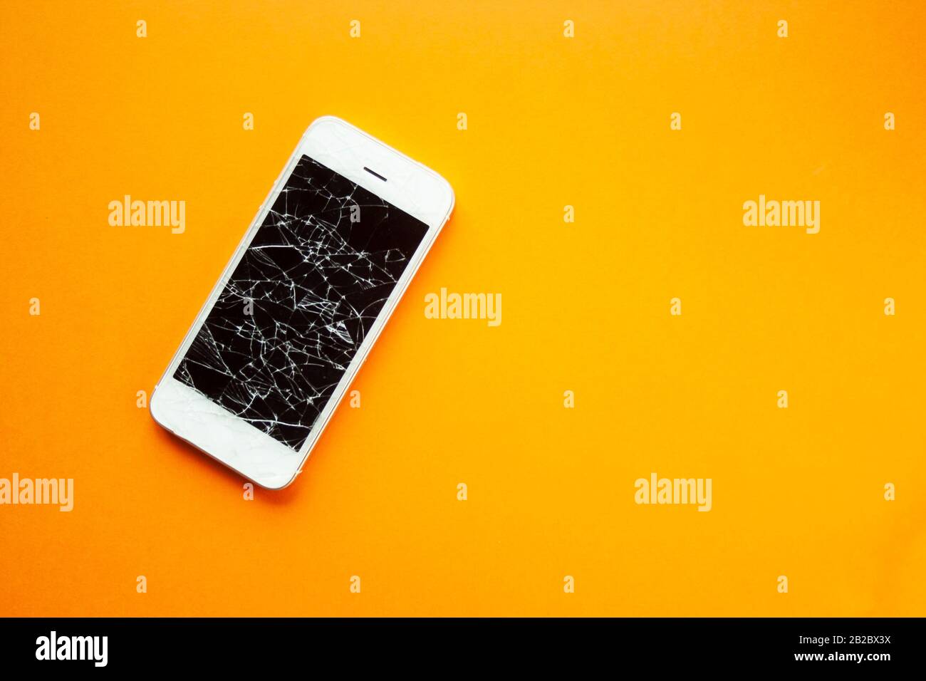 Broken screen of smartphone on the orange background. Smashed glass of ...