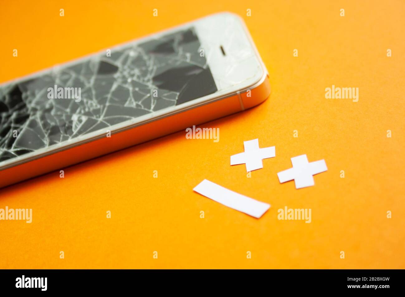 Broken smartphone with cracked destroyed screen on orange background ...