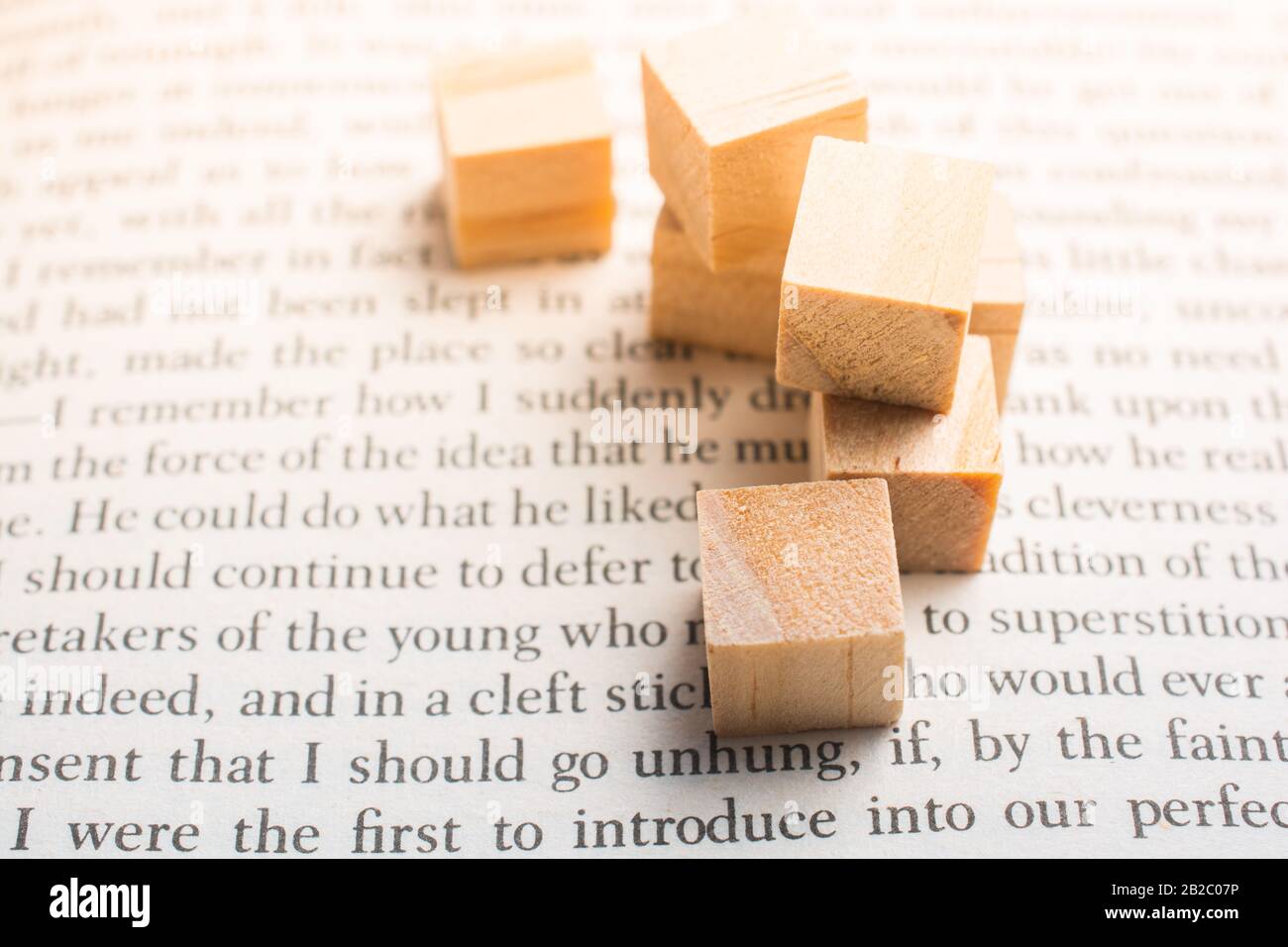 wooden toy cubes placed on a book page in English Stock Photo - Alamy