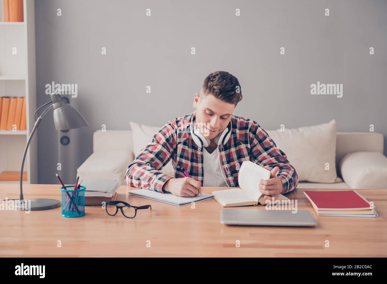 Happy student reading book and making notes for lecture Stock Photo - Alamy