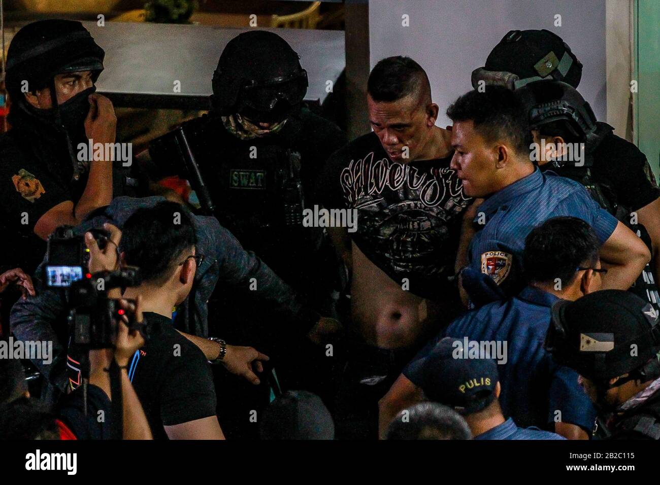 Manila, Philippines. 2nd Mar, 2020. Policemen and security guards grab ...